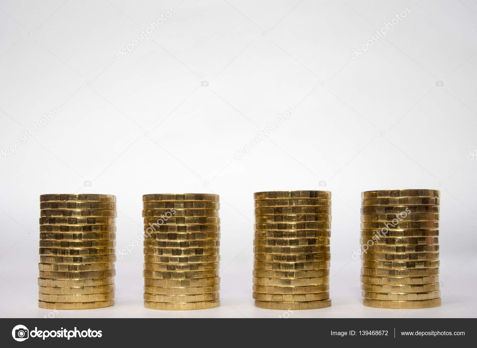 Four identical height of the stack of coins on a light background, the ...