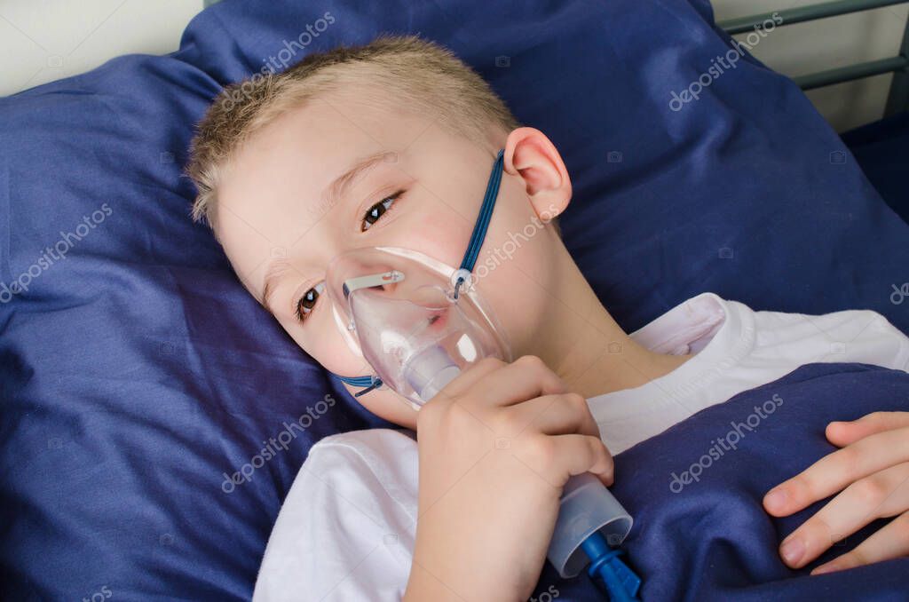Niño enfermo respirando a través de la máscara del inhalador. Uso de ...