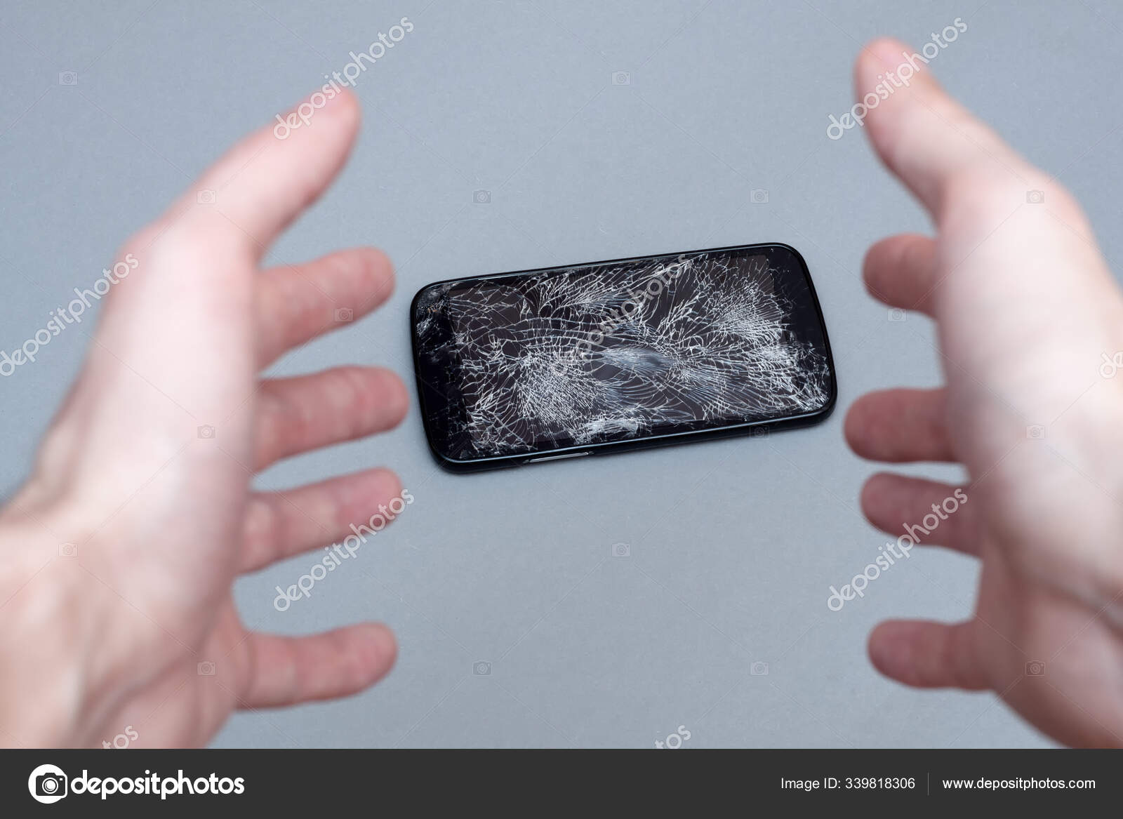 Man dropping his smartphone and trying to reach it. Phone screen is ...
