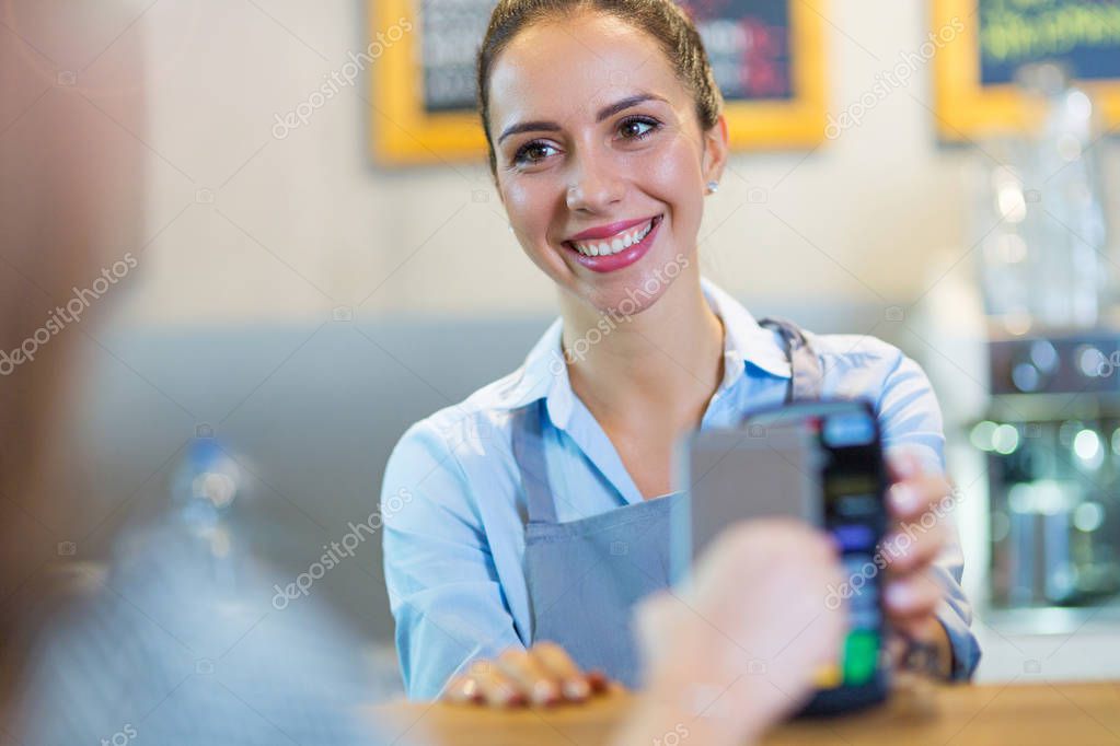 Cliente pagando a través del teléfono móvil en el café 2023