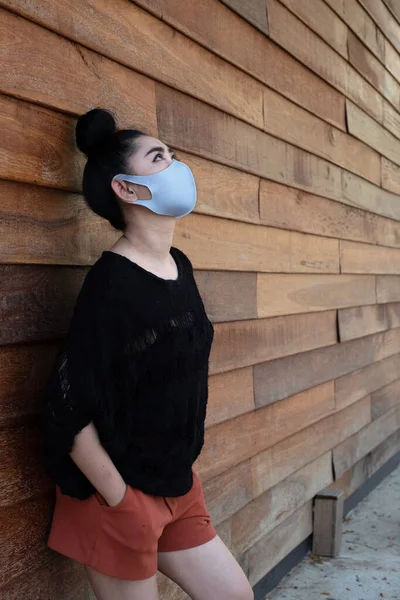 Close up young Asia woman putting on a medical mask to protect from airborne respiratory ...