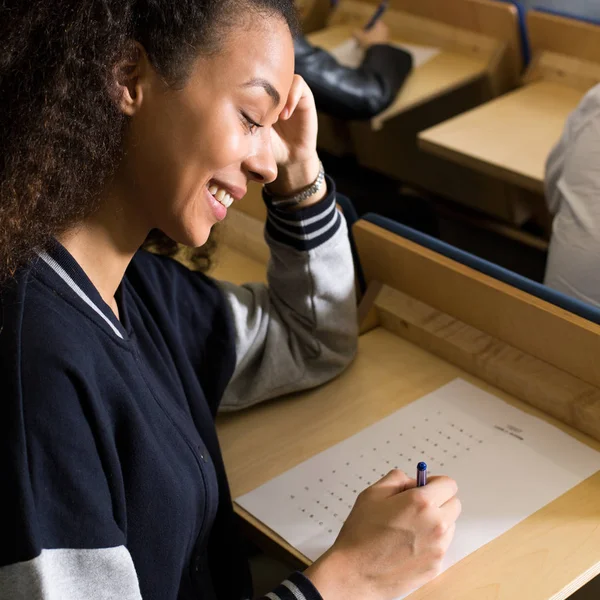 Happy student writing easy exam - Stock Image - Everypixel