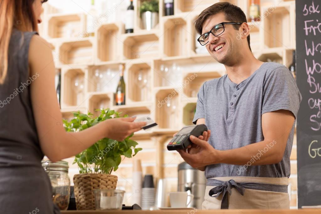 Smiling barista with costumer paying by card — Stock Photo ...