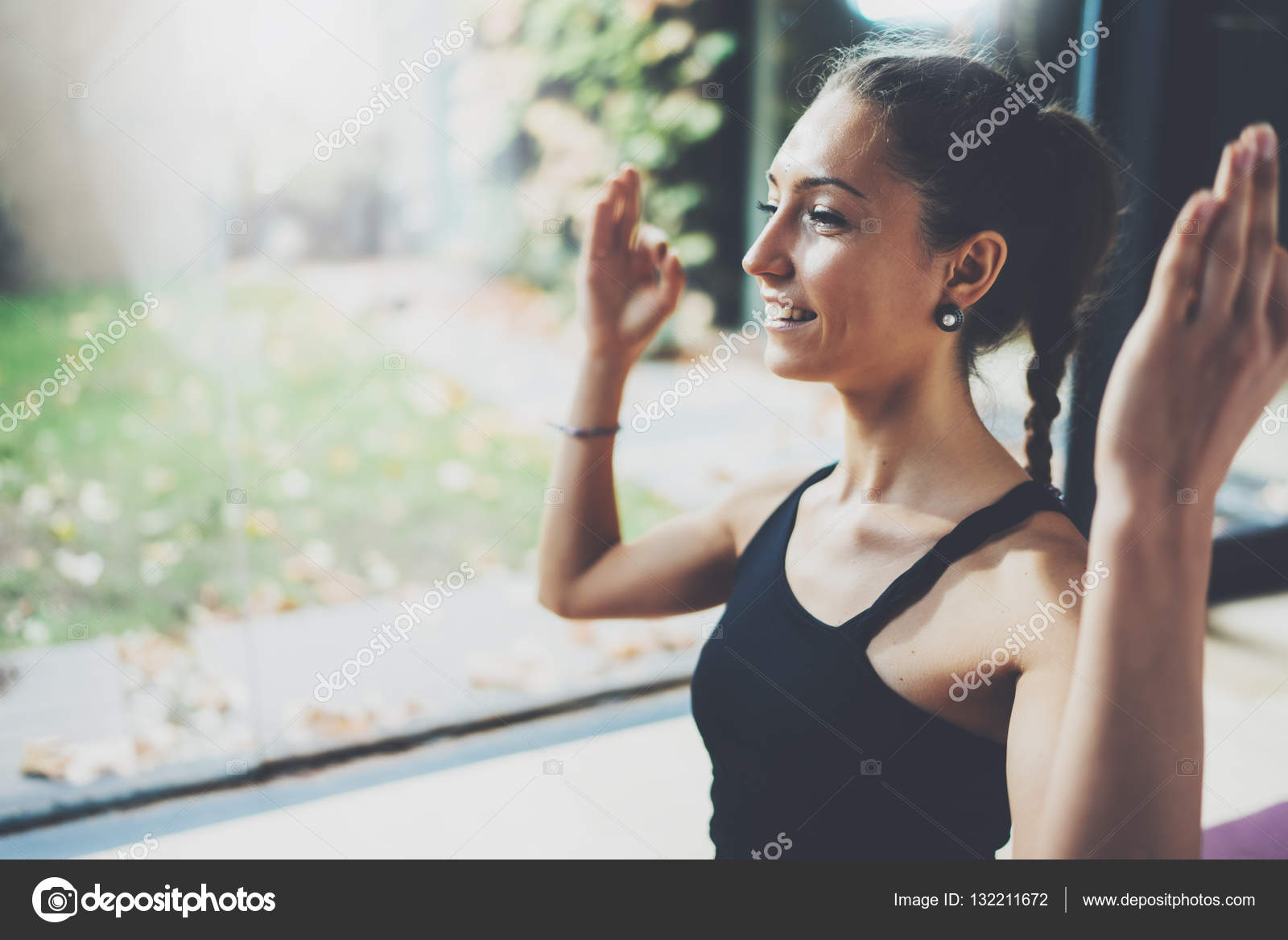 Portrait of gorgeous young woman practicing yoga indoor. Beautiful girl smiling during practice ...