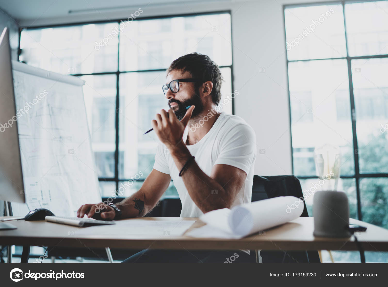 Young professional man wearing eye glasses working at modern loft ...