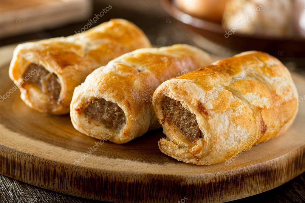 Delicious homemade sausage rolls on a wooden serving platter. Stock ...