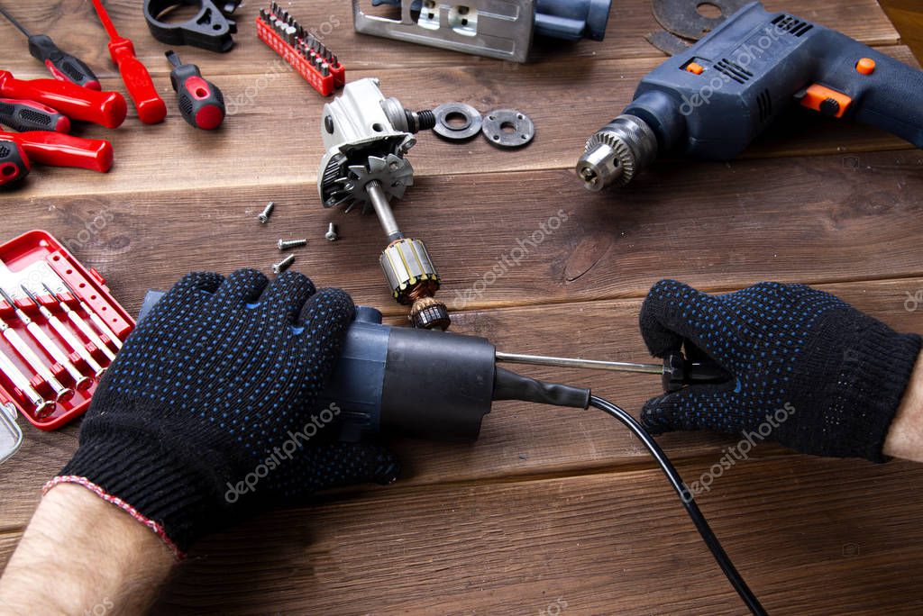 el maestro repara el mecanismo roto el ctrico: el taladro, el cortador ...