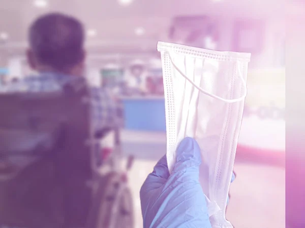 Hand holding the hygienic mask,blurred Elderly patients in hospital ...