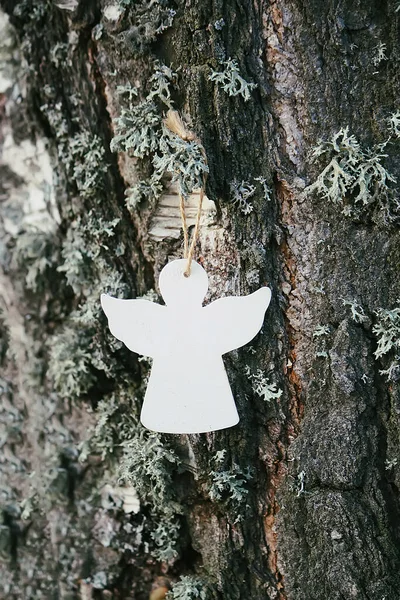 white wooden angel on a tree trunk - Stock Image - Everypixel