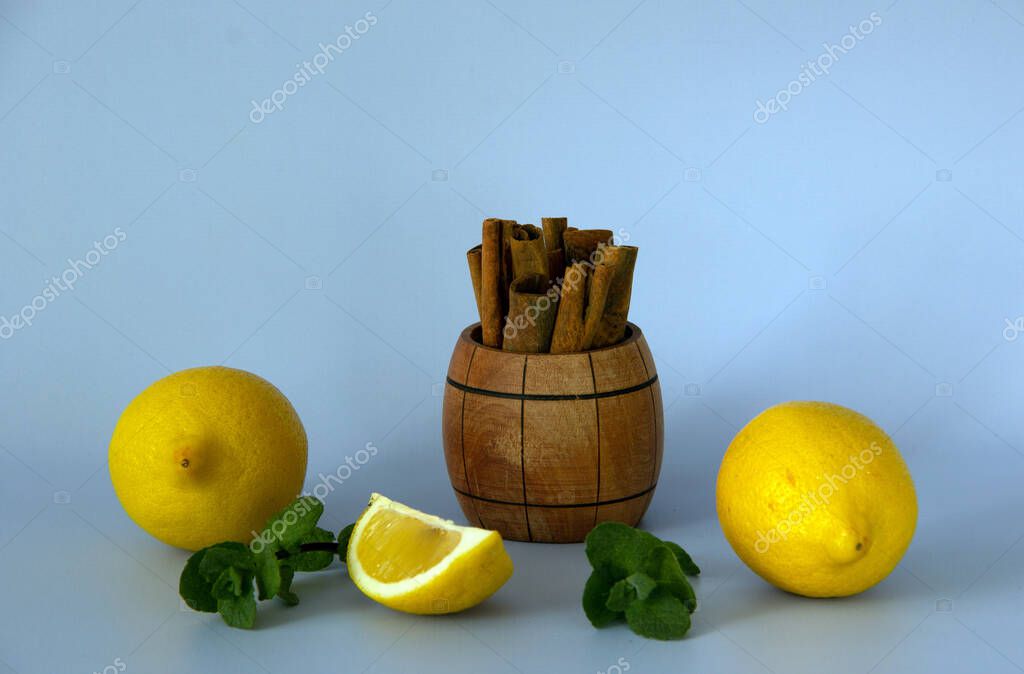 Limón, menta, barril de madera decorativa con canela sobre un fondo ...