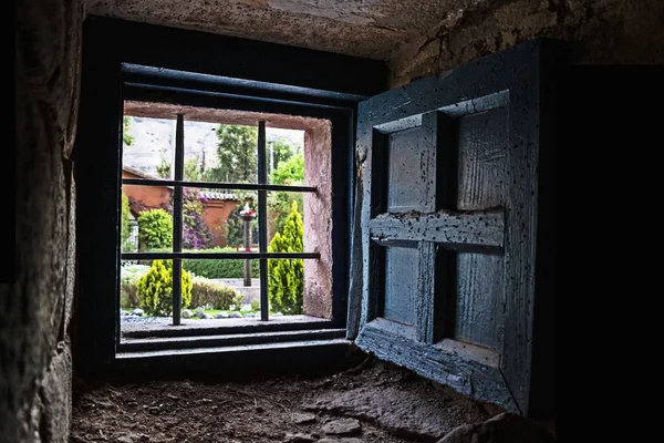 Garden view through an old colonial style window with fence and shutter ...