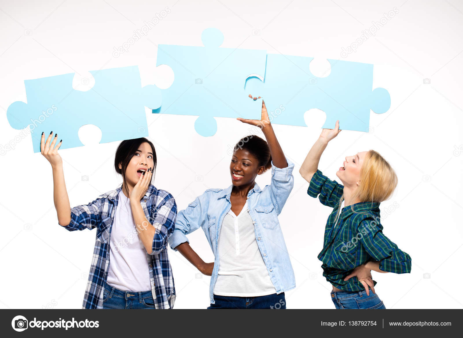 Three friends of different ethnicity with puzzle pieces on white ...