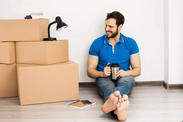 man lying on the floor with packing boxes - Stock Image - Everypixel