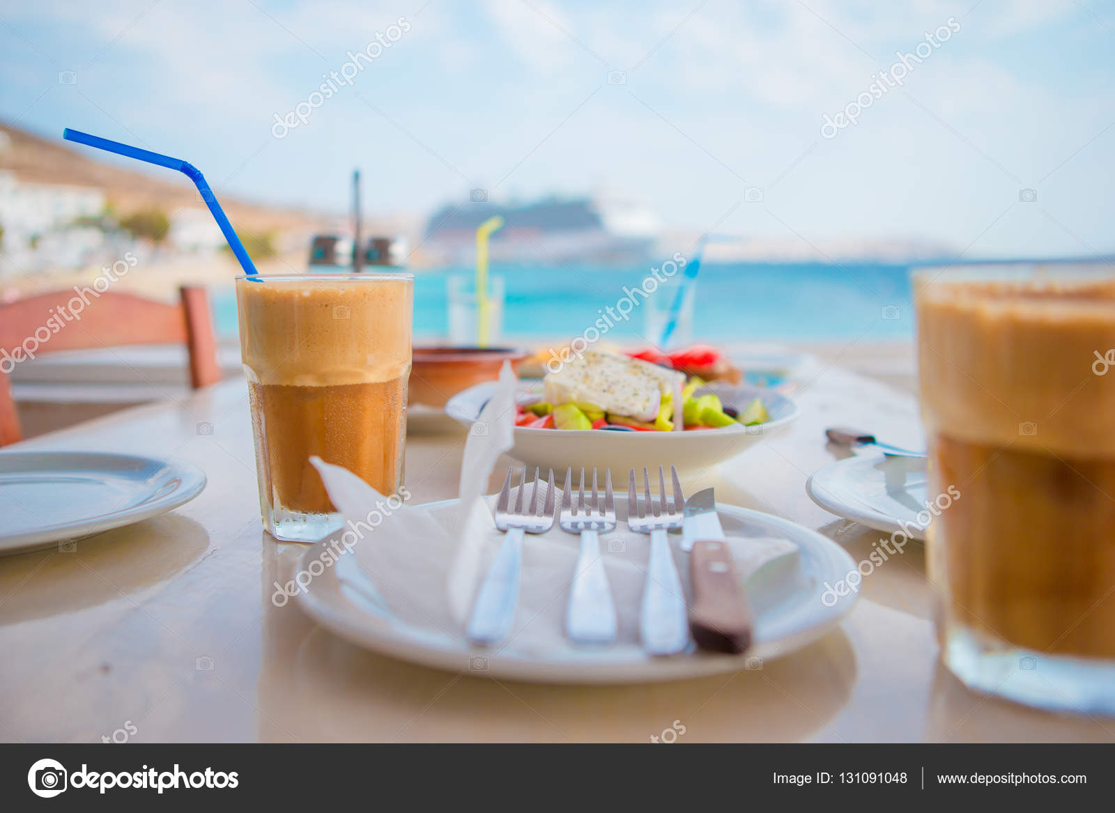 Frappe on the table background sea and big lainer. Summer iced coffee ...
