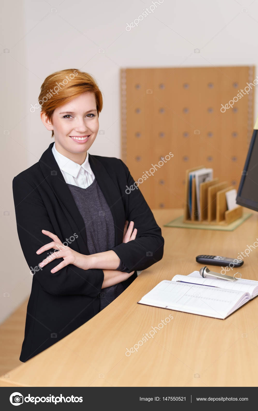 Young redhead hotel receptionist Stock Photo by ©racorn 147550521