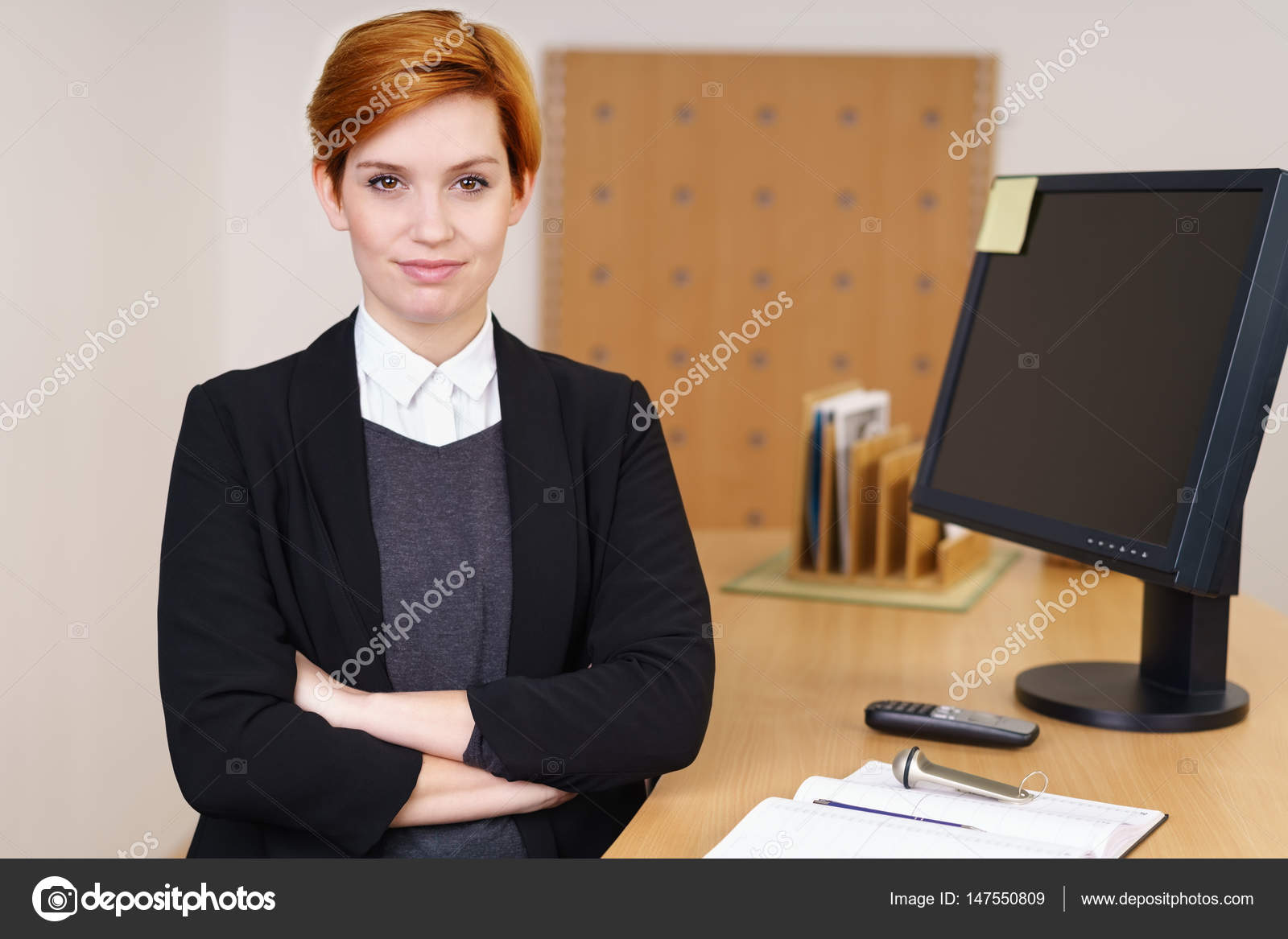 Young redhead hotel receptionist Stock Photo by ©racorn 147550809