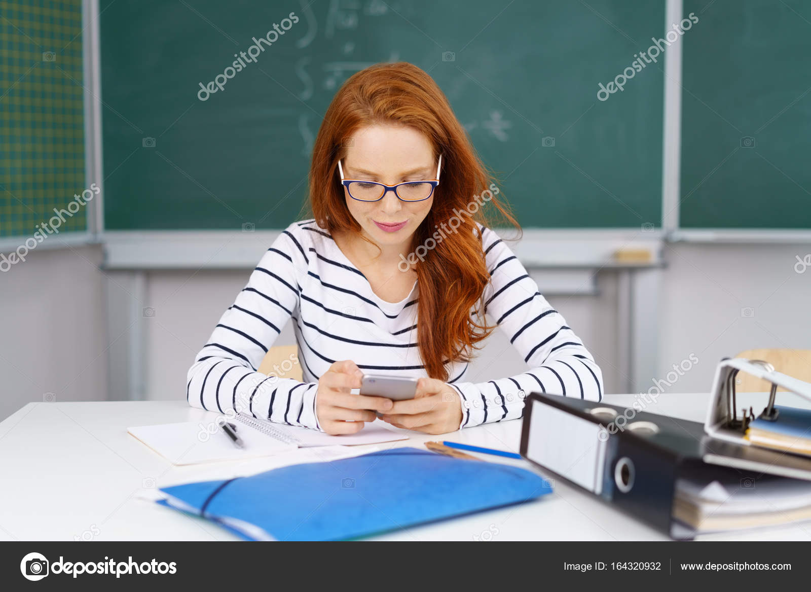 Attractive young student using her mobile phone — Stock Photo © racorn ...