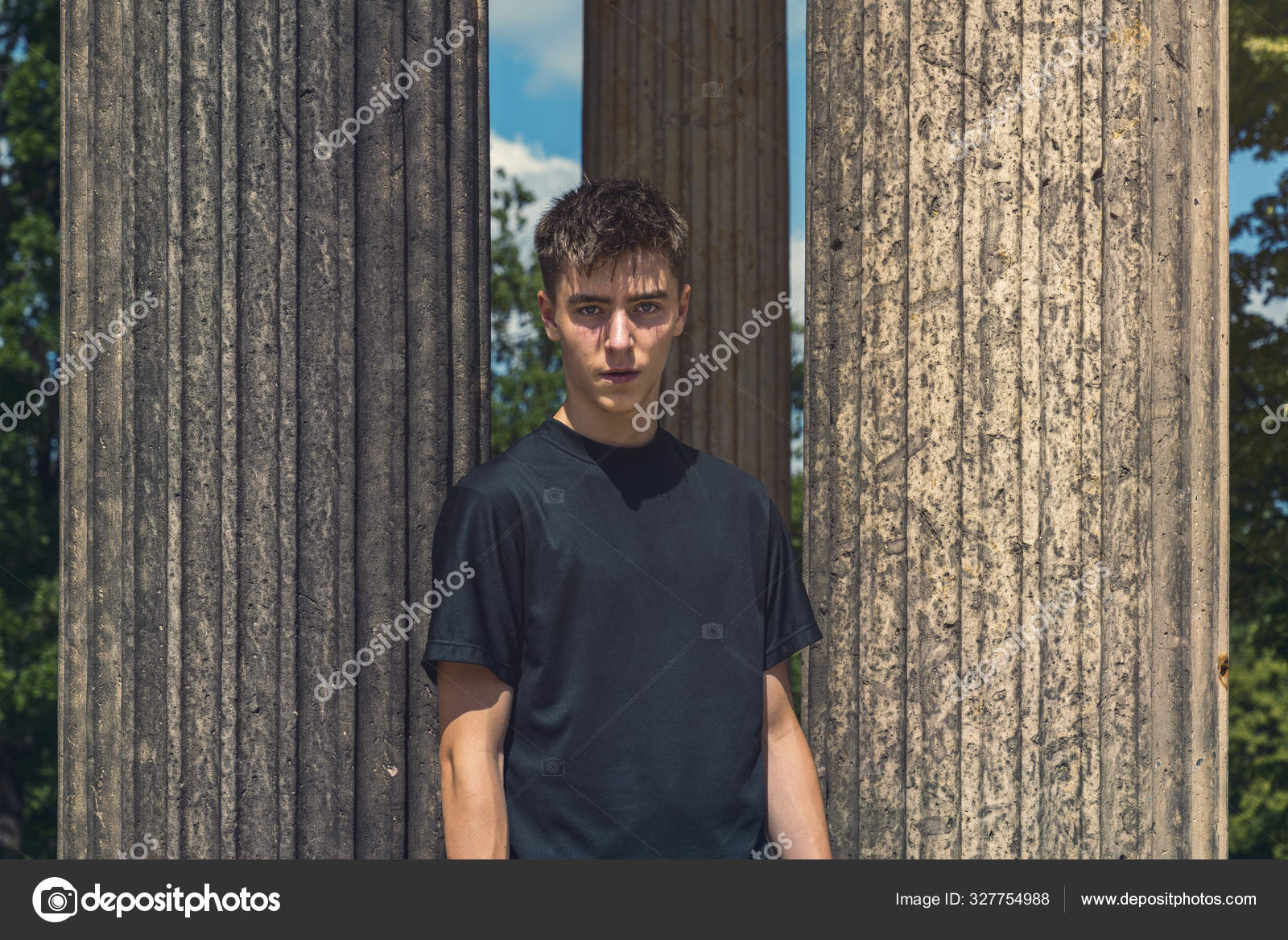 Portrait of a young man standing between ancient columns — Stock Photo ...