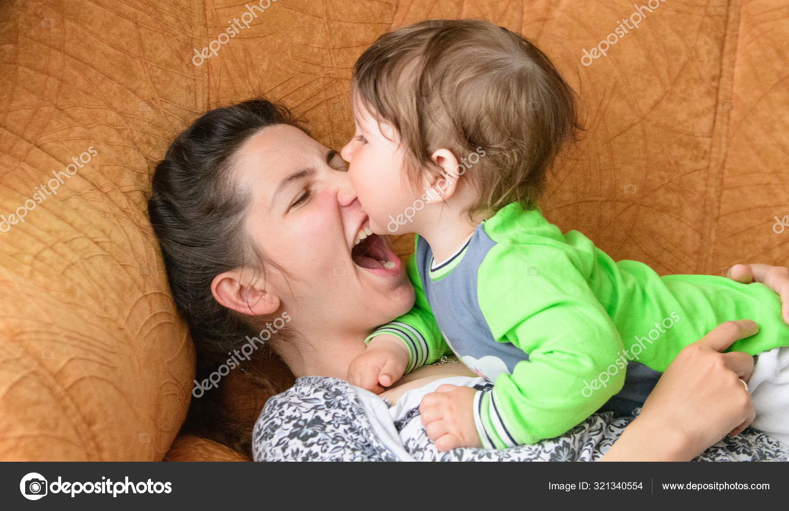 Baby bites moms nose. Happy mother with baby. A boy bites his mothers ...