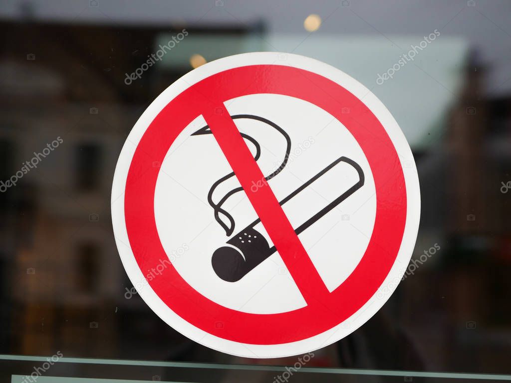 No fumar etiqueta adhesiva en vidrio con fuera de foco institución ...