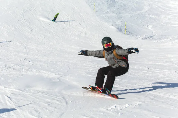 Snowboarder sliding down a slope on a sunny day — Stock Photo ...