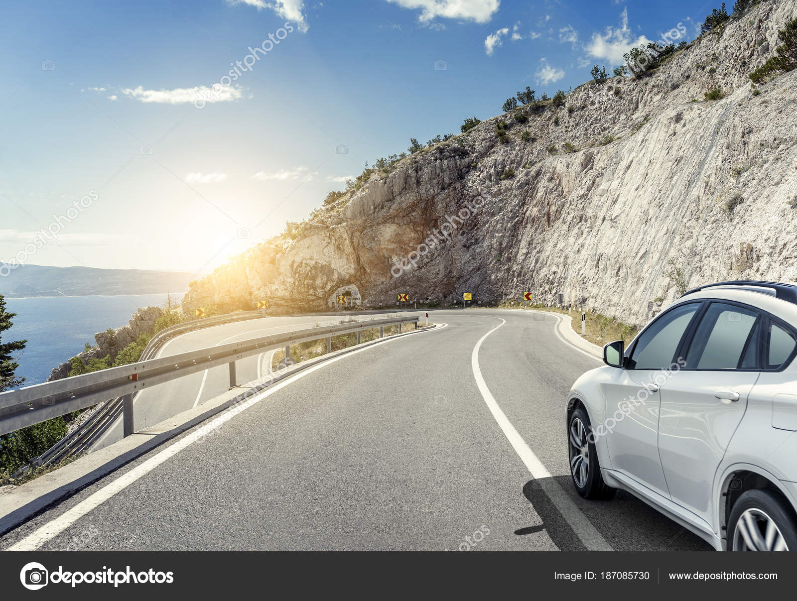 A white car rushing along a high-speed highway in the sun. Stock Photo ...