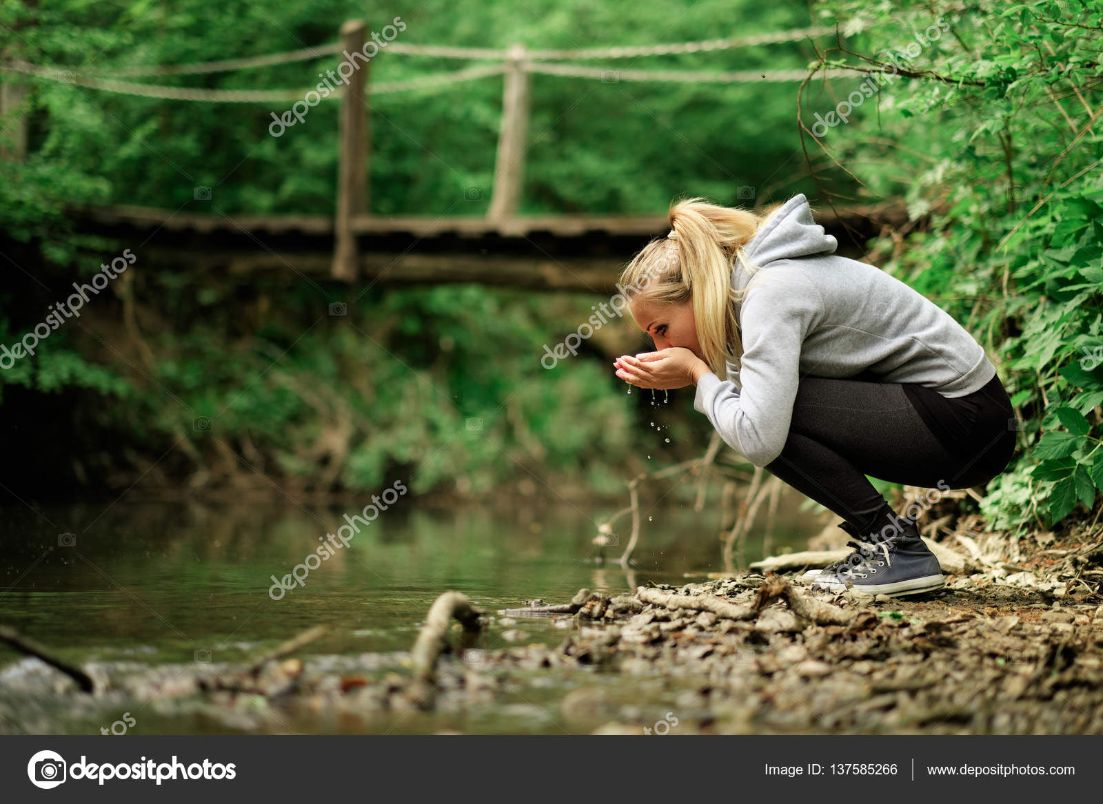 Woman drinking a fresh water stream Stock Photo by ©linux1987 137585266
