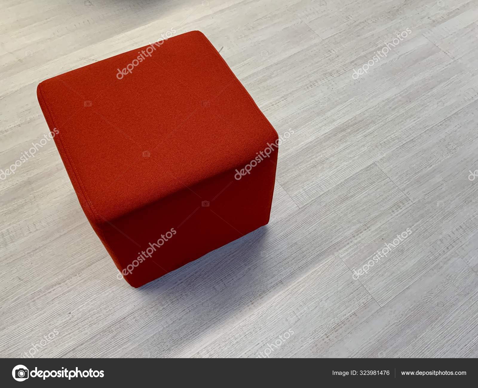 Red cube on a gray background. One soft chair on the floor. Comfortable ...