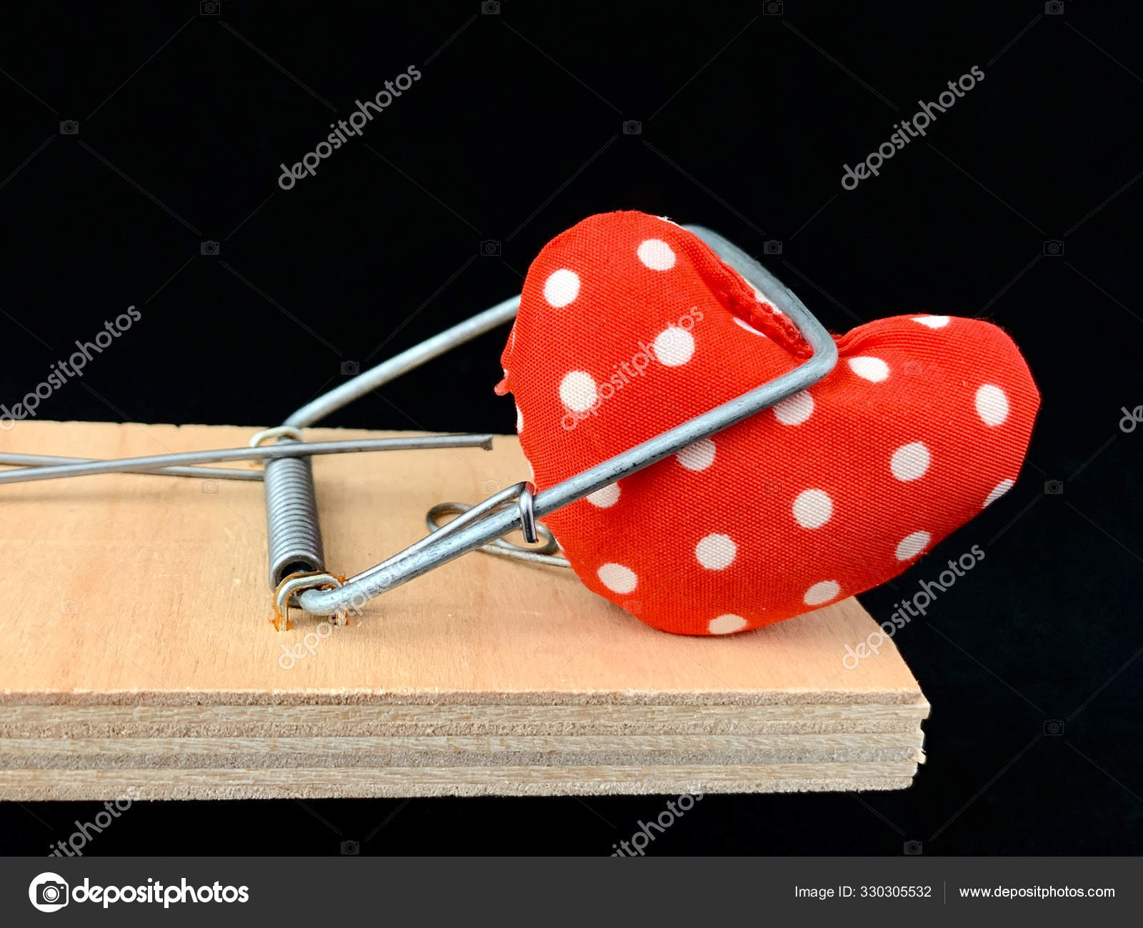 Heart in a mousetrap on a black background. A trap with a heart, Love ...
