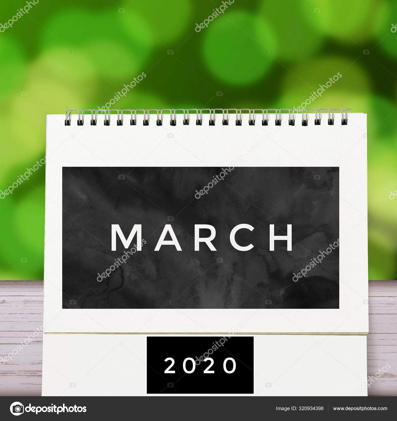 White blank paper desk spiral March calendar on wood with green ...