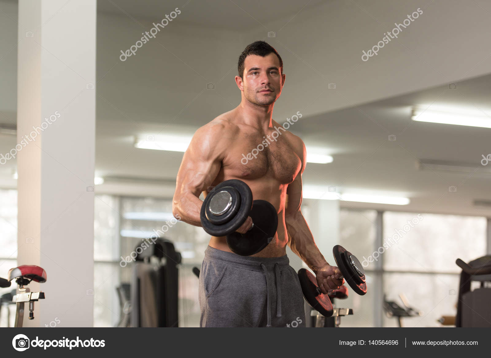 Muscular Man Exercising Biceps With Dumbbell — Stock Photo © ibrak ...