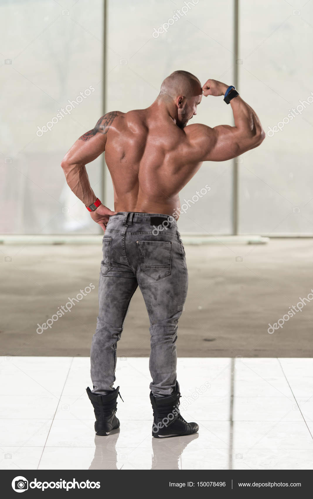 Muscular Man Flexing Back Muscles Pose Stock Photo by ©ibrak 150078496
