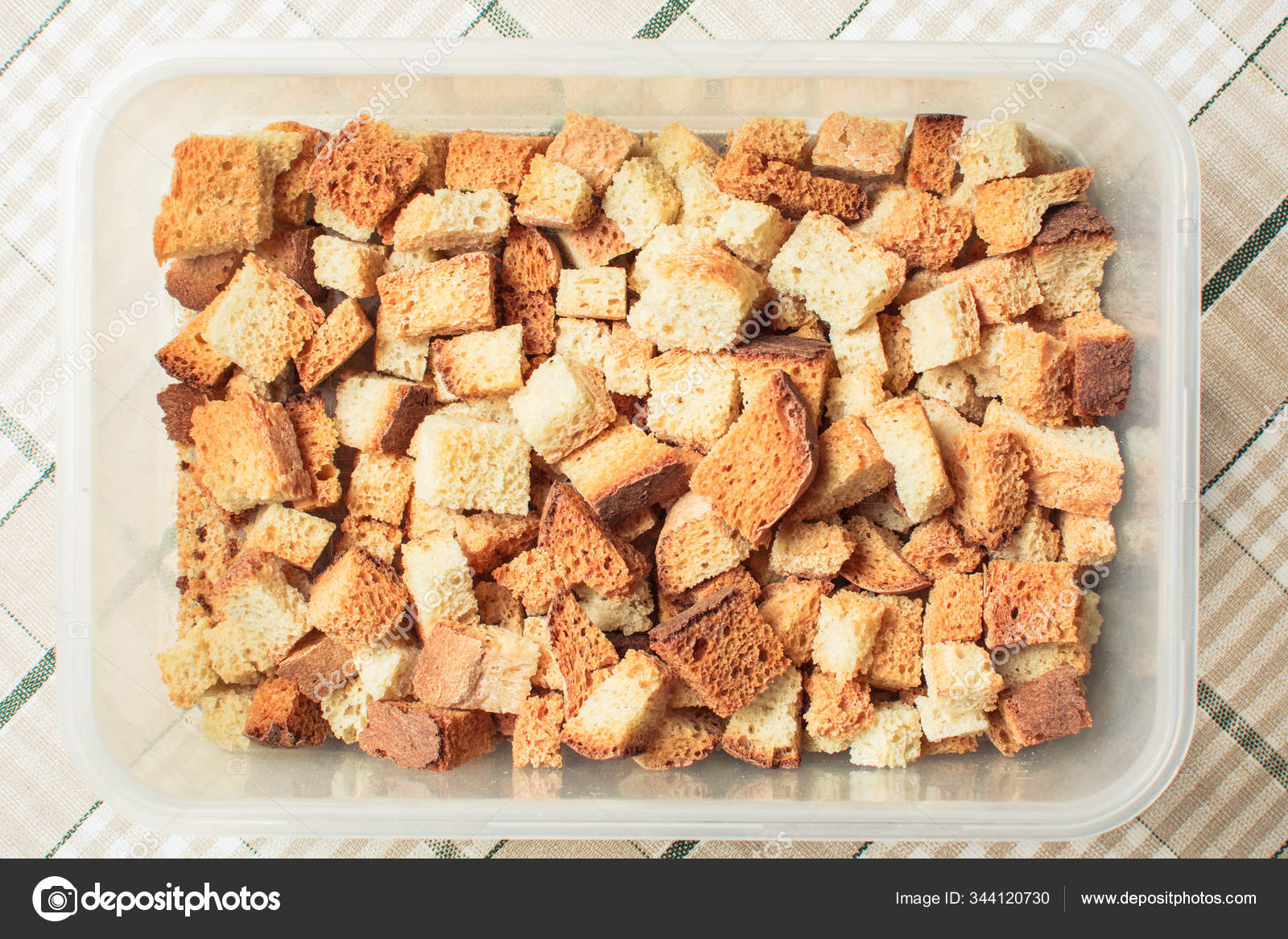 Baked sliced white bread rusks in white container on kitchen table ...