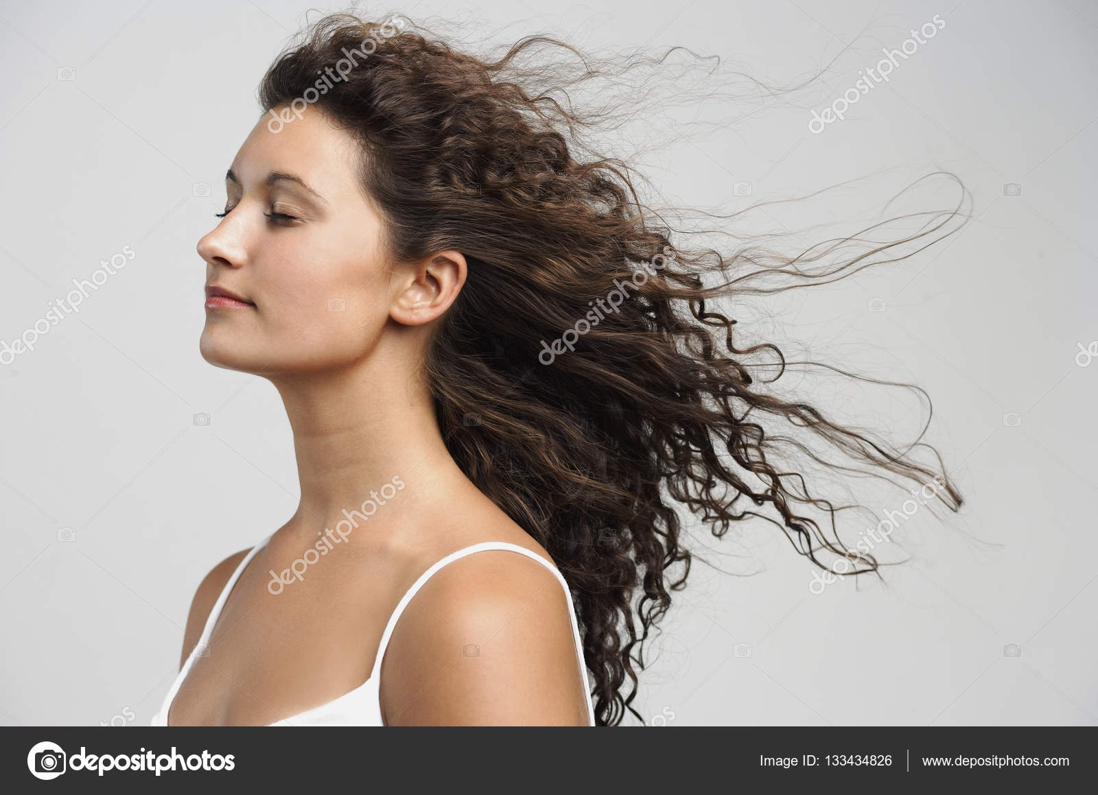 Woman with wind blowing in face — Stock Photo © MicrostockAsia #133434826