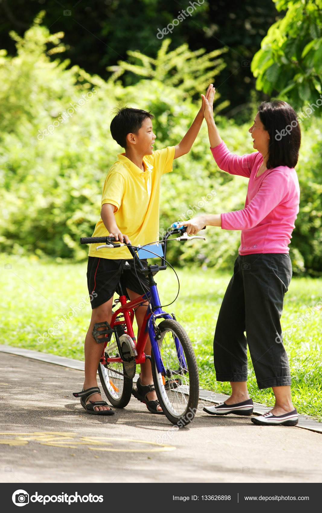 Mother guiding son on bicycle Stock Photo by ©MicrostockAsia 133626898