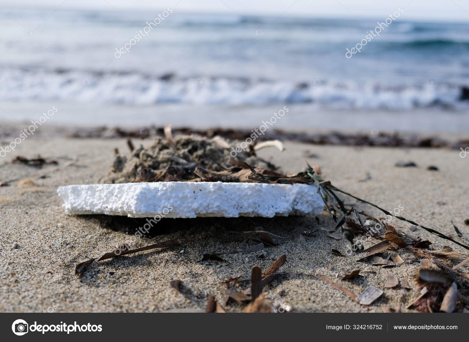 Polystyrene garbage on sandy sea shore on sunset golden light,pollution ...