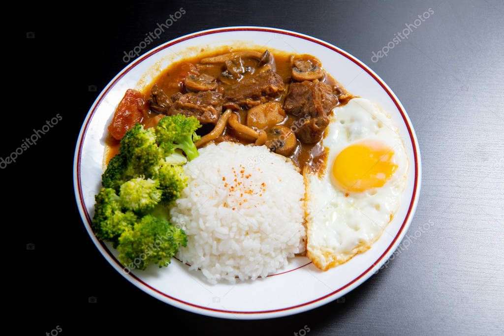 Carne de res Curry Arroz sobre fondo de madera negro (Onsen tamago ...
