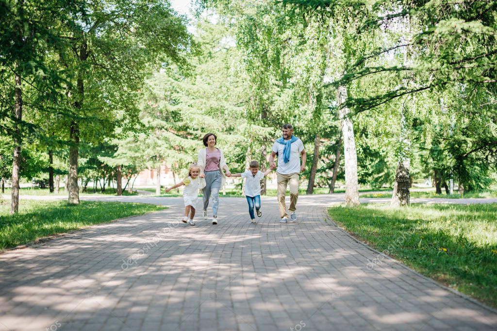 Gran familia con dos niños caminando en el parque. 2023