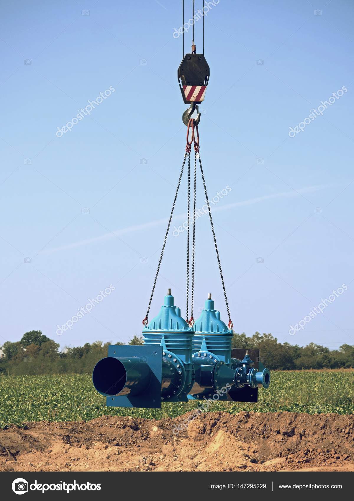 Crane handling 500mm pipe with gate valves. Construction process Stock ...