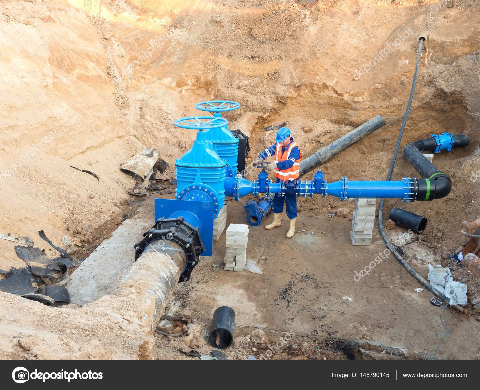 Worker in safety clothes drive valve conduit on City potable water pipe ...
