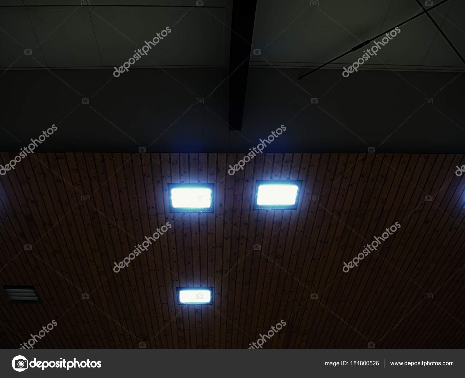 Luminous ceiling of square tiles. Wooden ceiling with lighting panels ...
