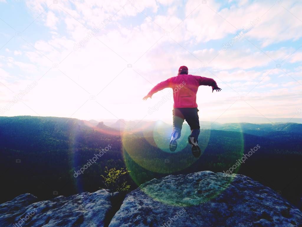 Saltando hombre. Joven loco está saltando en la cumbre rocosa sobre el ...