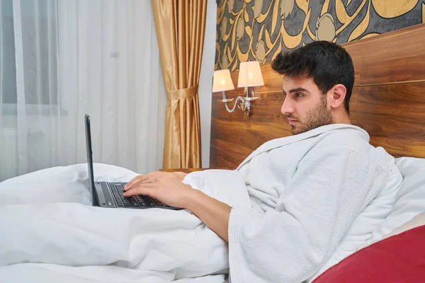 Laptop computer on white bed sheets in cozy room with copy space blank ...