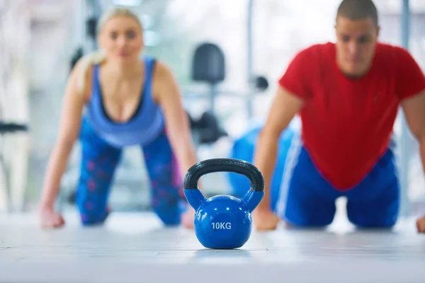 Group having functional fitness training with kettlebell in sport gym ...