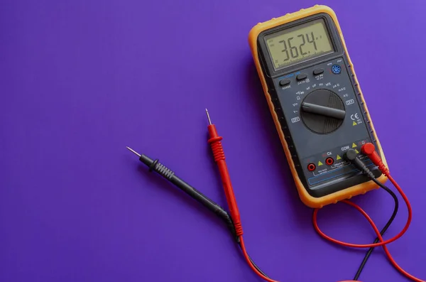 Multimeter on a lilac background. Yellow Multimeter, A multimeter or a ...