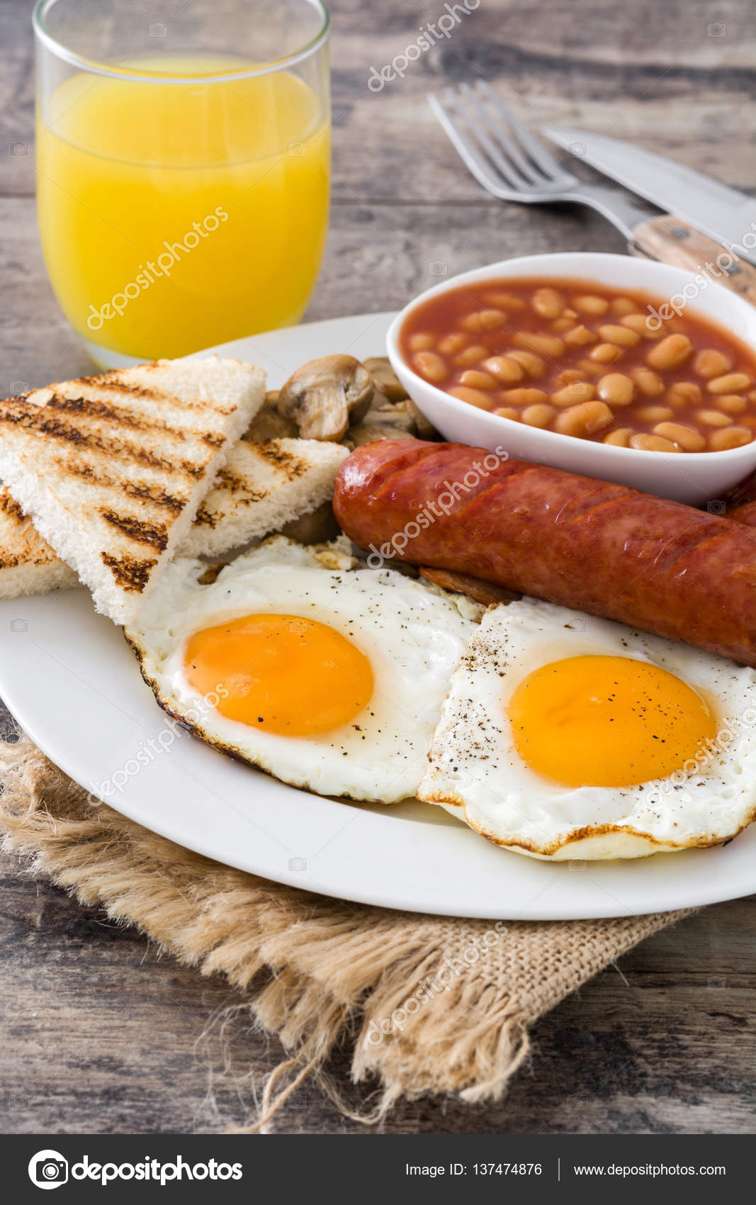 Traditional full English breakfast with fried eggs, sausages, beans ...