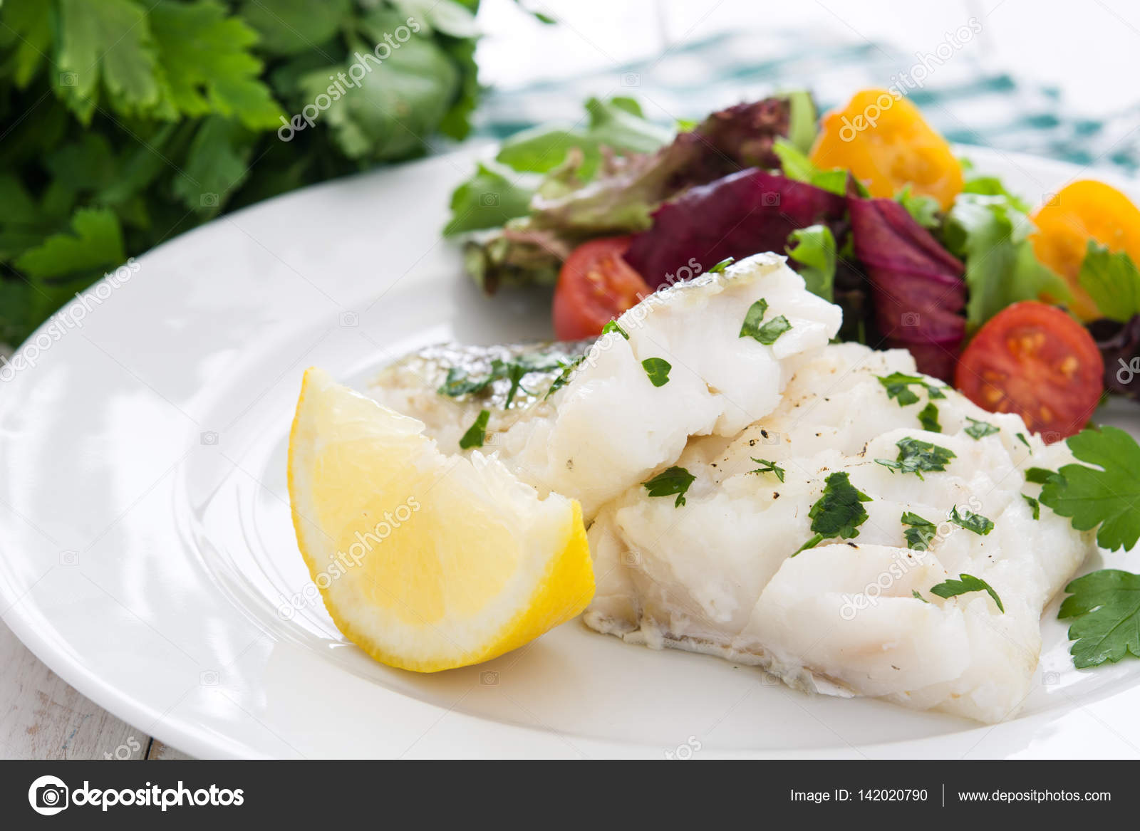 Fried cod fillet and salad in plate on white wooden background Stock ...