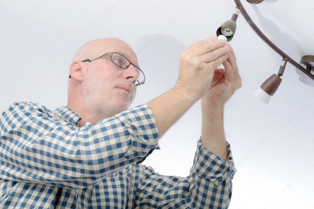 Man replacing the light bulb at home Stock Photo by ©philipimage 126309932