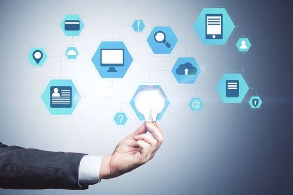 Hand holding lamp and business interface hologram. Global business and ...