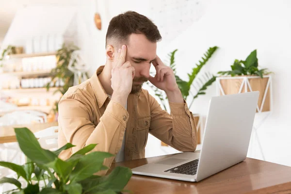 Young handsome man trying to concentrate on tasks works in his laptop ...